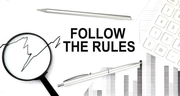 FOLLOW THE RULES text on the document with pen,graph and magnifier ...