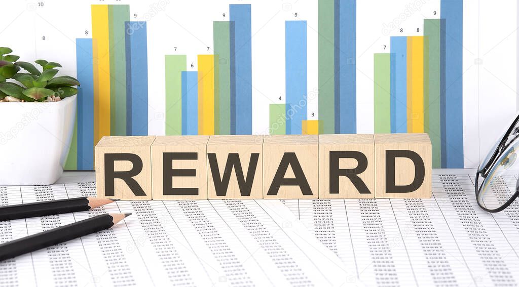 Palabra de recompensa escrita en el bloque de madera con carta, vasos y ...