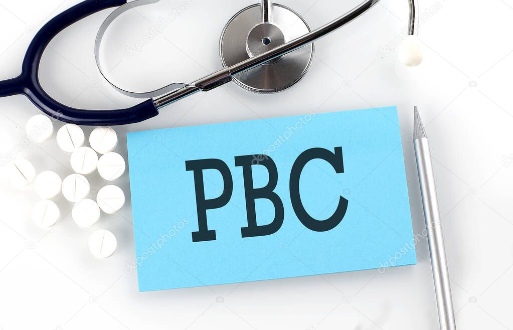 Texto PBC en una mesa con estetoscopio, pastillas y pluma, concepto ...