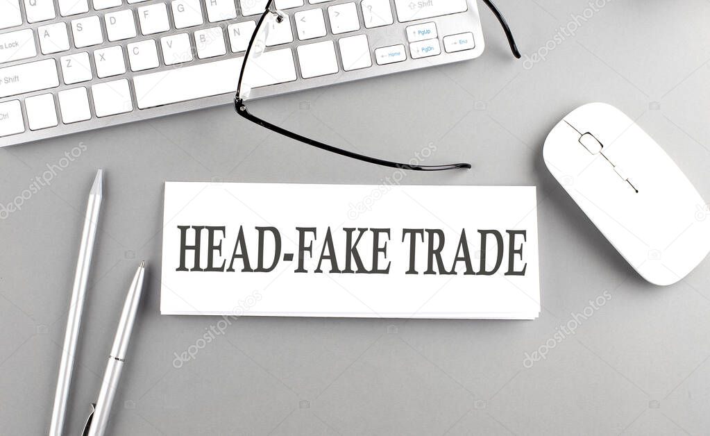 HEAD FAKE TRADE texto sobre papel con teclado sobre fondo gris 2022