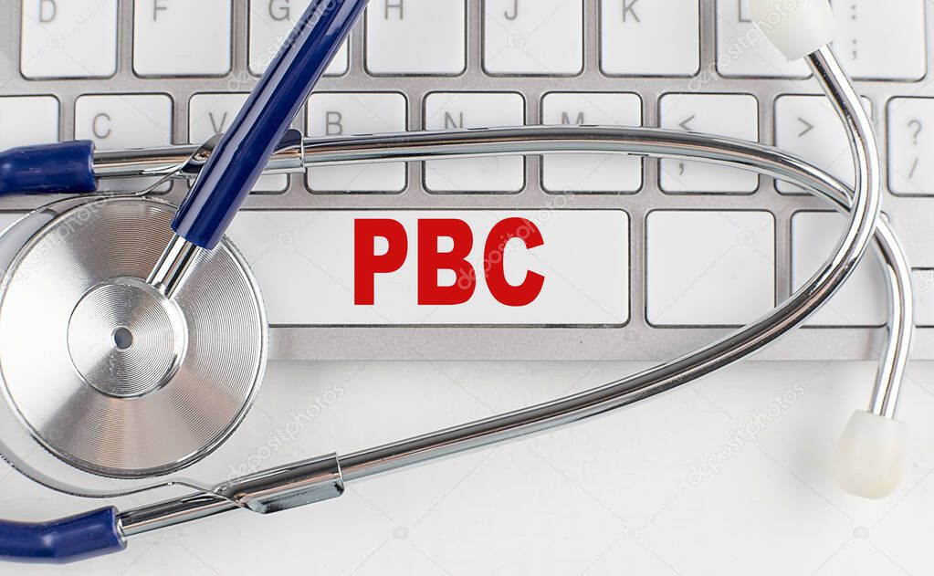 Texto PBC en un teclado con estetoscopio, concepto médico 2023