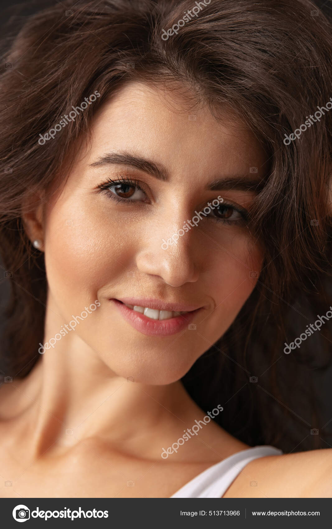 Close-up portrait of young beautiful girl without makeup isolated over dark studio background ...