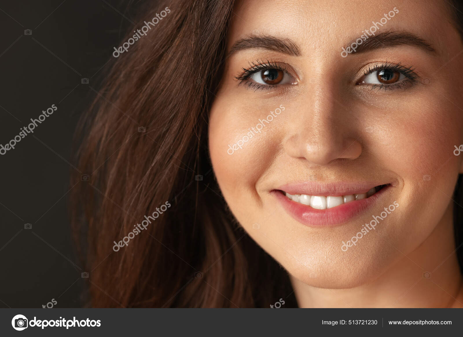 Close-up portrait of young beautiful girl without makeup isolated over dark studio background ...