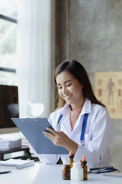 An Asian female doctor works in the office of a hospital, she is a ...