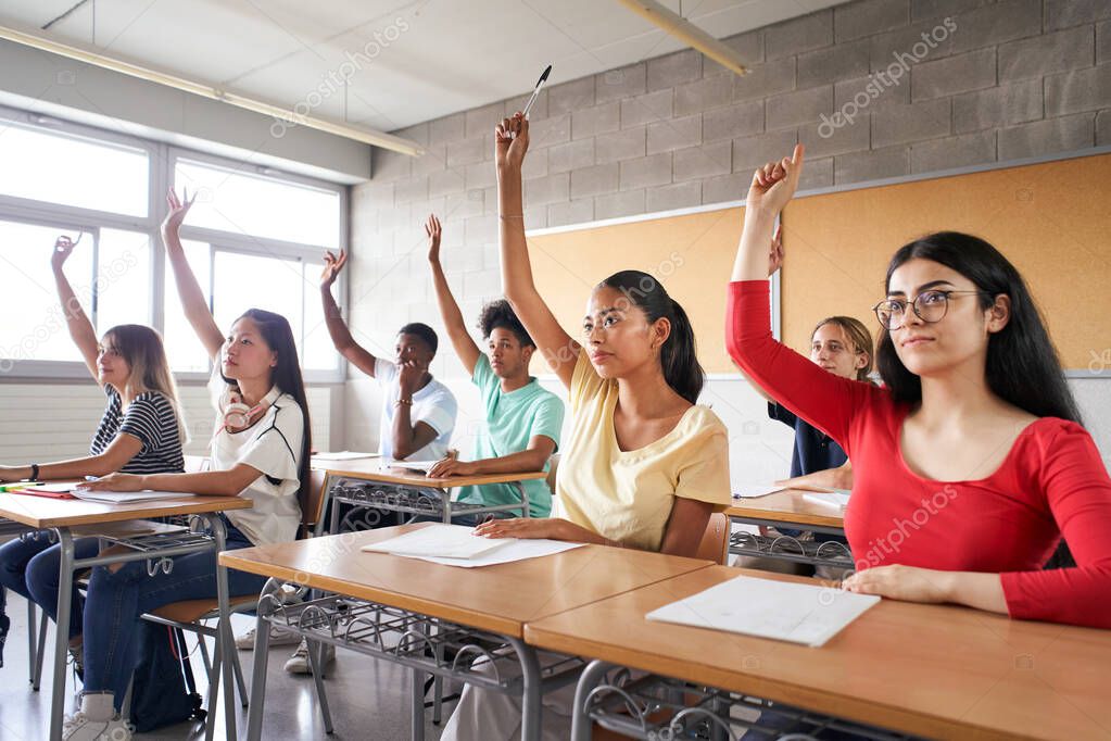Estudiantes multiétnicos en clase con las manos levantadas. Jóvenes ...