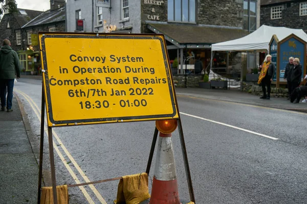 Yellow sign with black text with information about a traffic convoy ...