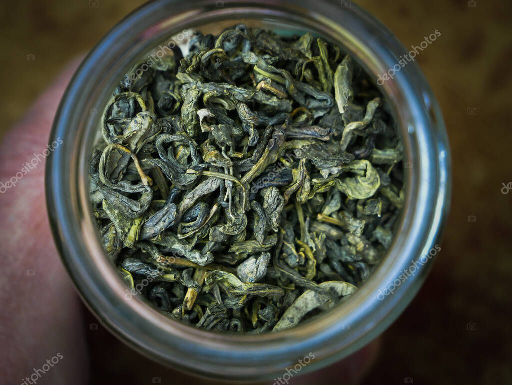 Hojas de té negro seco en tapa de botella de vidrio 2023