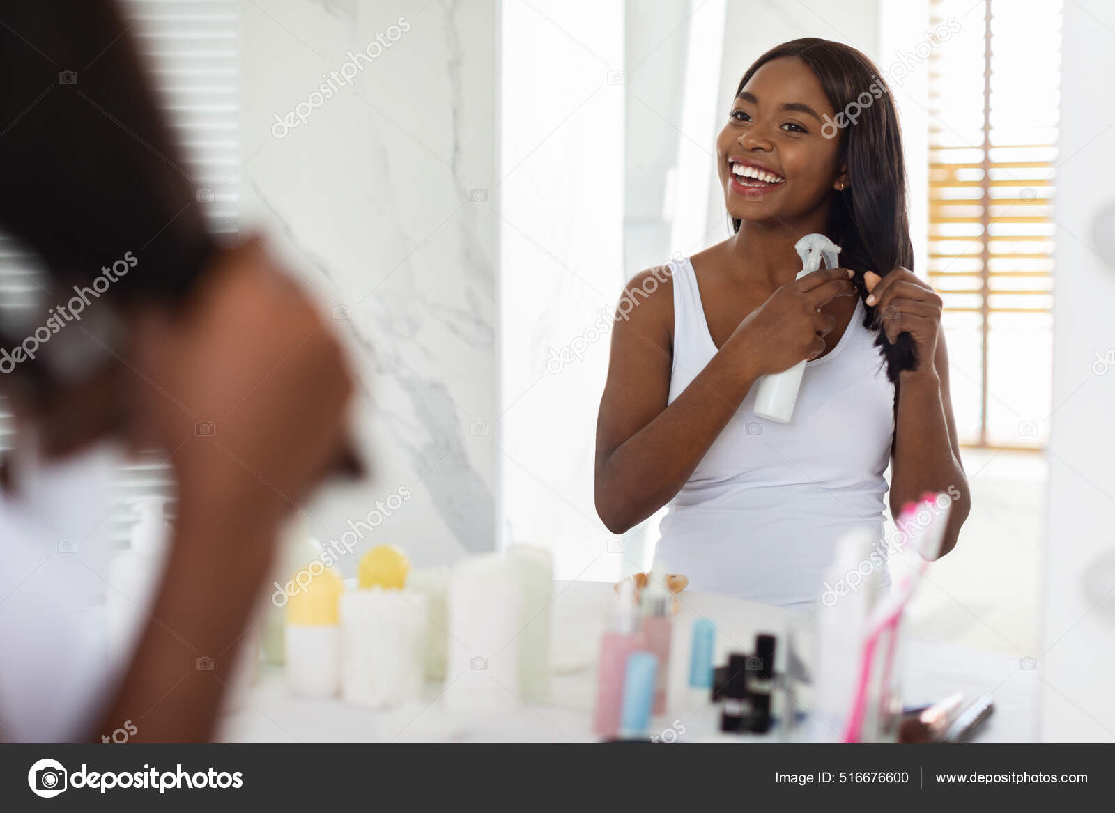 Haircare Smiling Black Woman Applying Hair Spray Standing Near Mirror