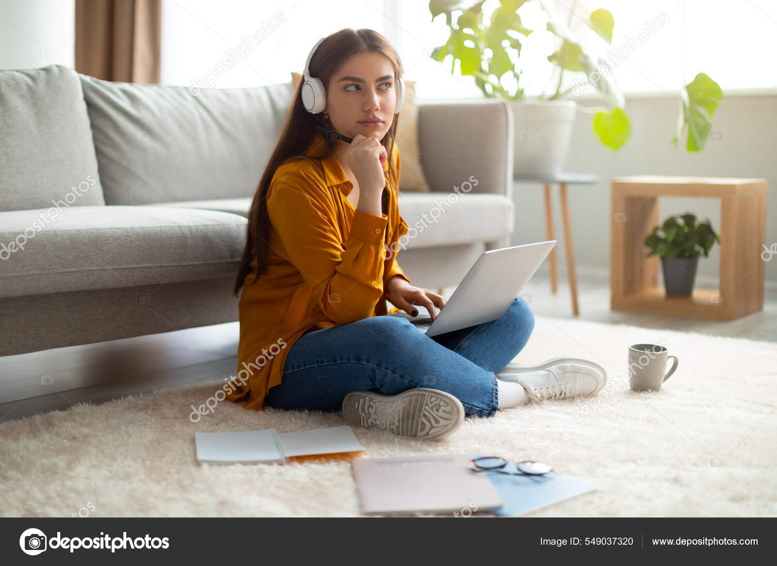 Online video call. Thoughtful young woman in headphones sitting on ...