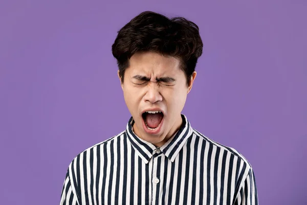 Scared asian man grimacing, screaming at purple studio Stock Photo by ...