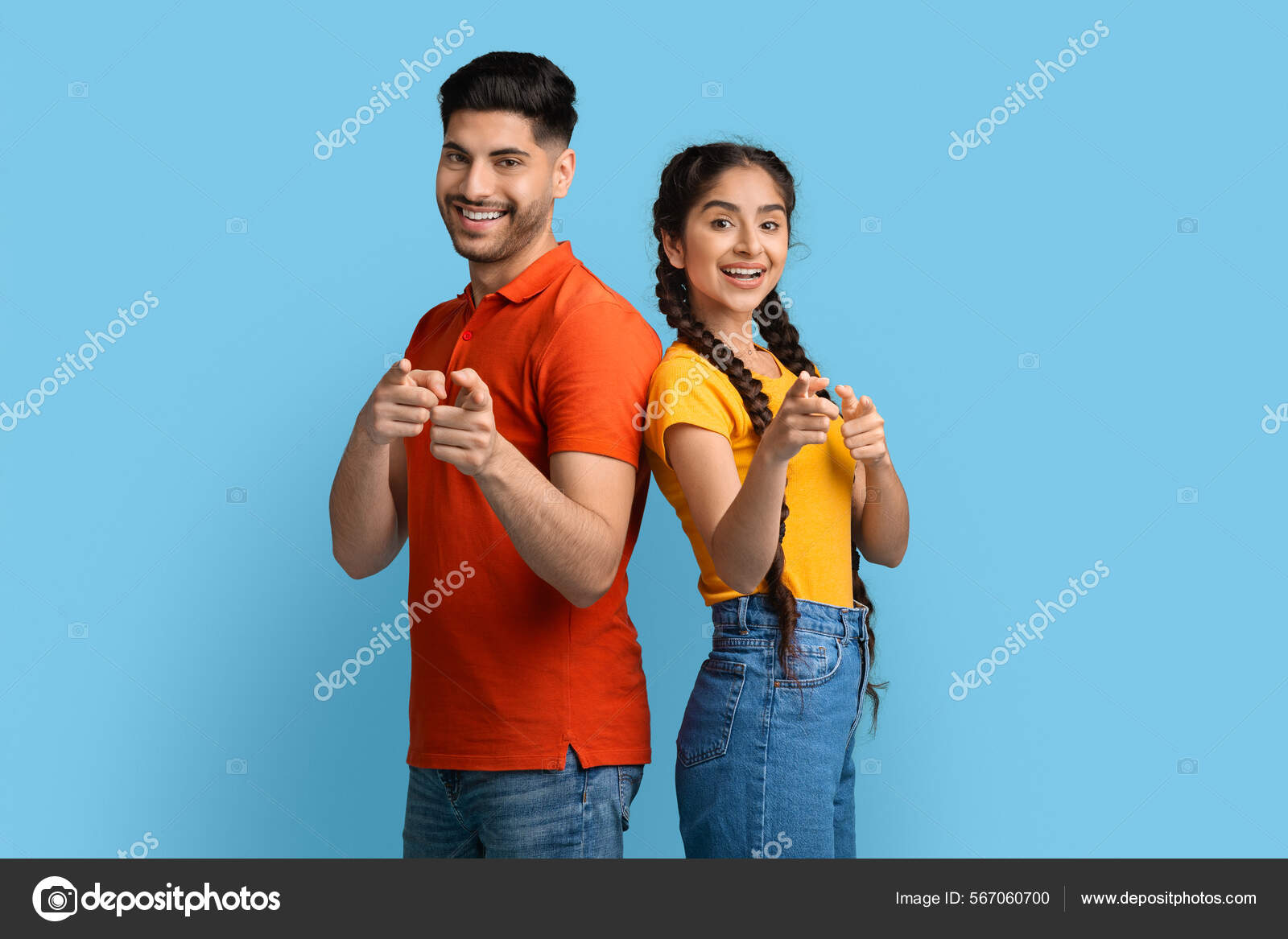 Gotcha. Young arabic couple pointing at camera with fingers and ...