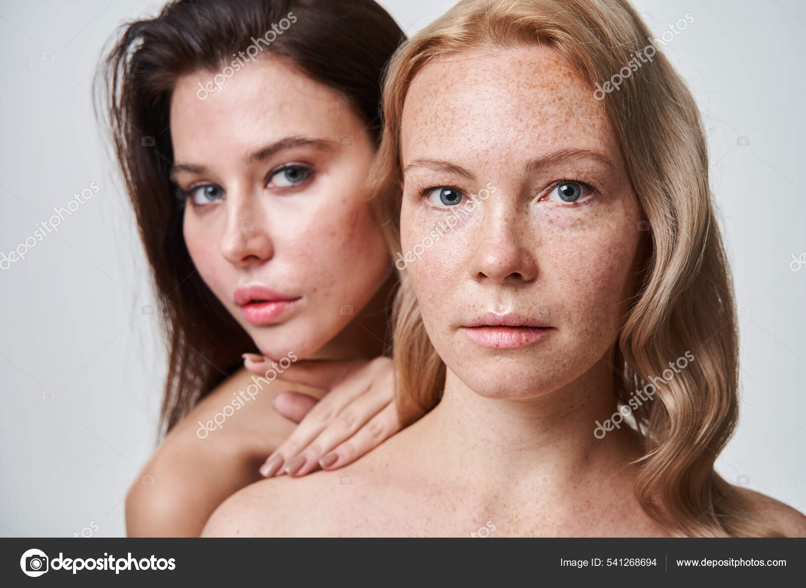 Two diverse girls standing behind of each other while posing at the ...