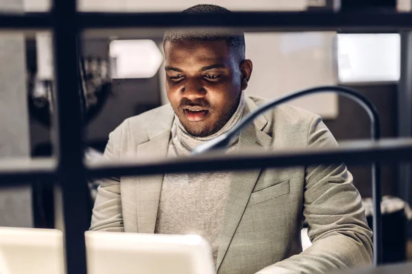 Young black african man relaxing using technology of laptop computer ...