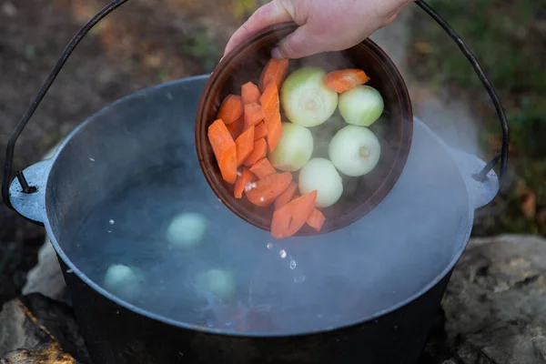 Fish soup prepared over an open fire. Cooking fish soup over an open ...