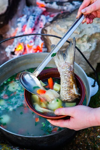Fish soup prepared over an open fire. Cooking fish soup over an open ...