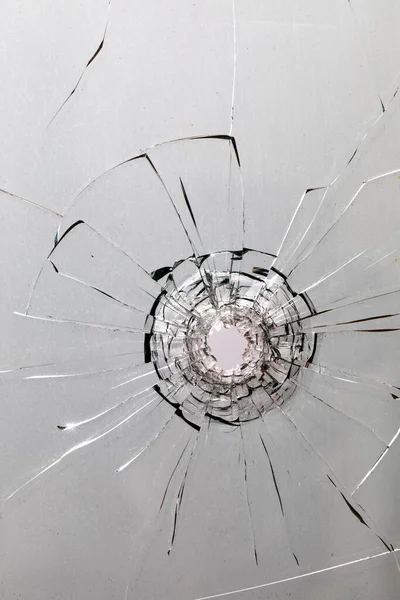 Bullet hole in the rock. Broken window, cracks. Abstract background or ...