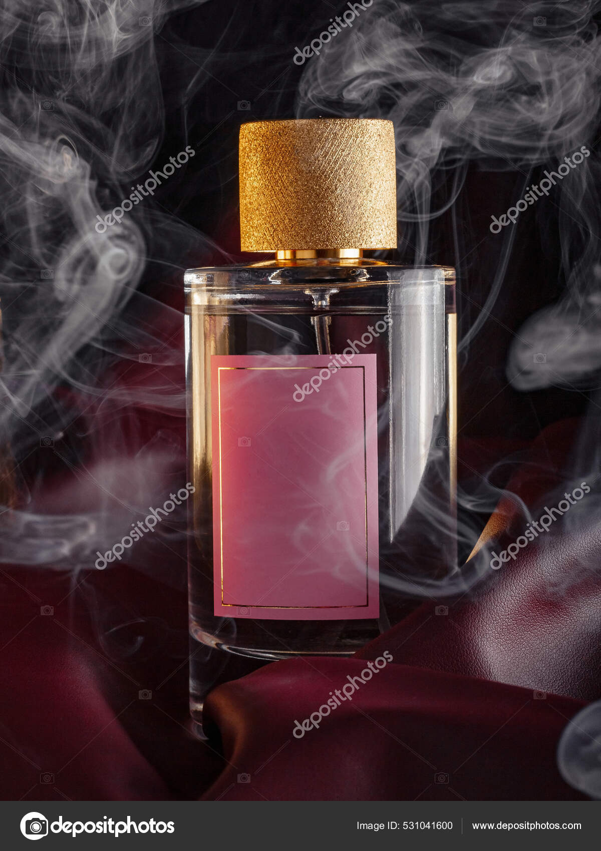 Bottle of perfume on a dark maroon background with smoke Stock Photo by ...