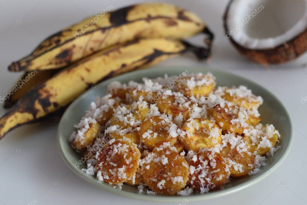 Ghee asado rodajas de plátano maduro, sumergido en la mezcla de azúcar ...
