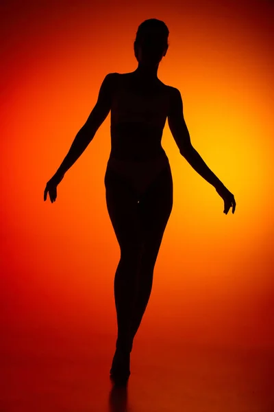 Silhouette of female full-length body isolated over orange background ...