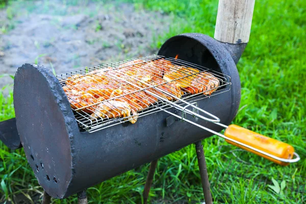 Chicken on grill outdoors. Barbecue on fire in summer. Good time ...
