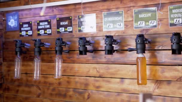 Draft Beer in Plastic Bottles Hanging on Beer Taps in Bar at Wall ...