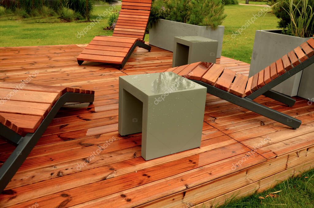 rocking chair on the pavement under the trees in the square. wooden ...