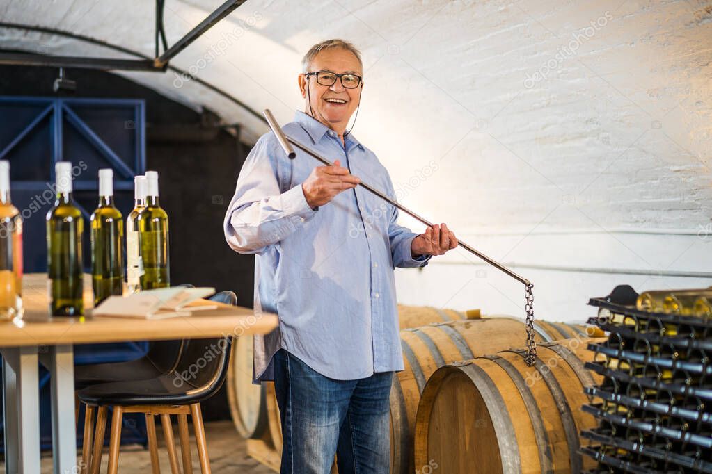 Retrato del hombre mayor que es dueño de la bodega. Está examinando la ...