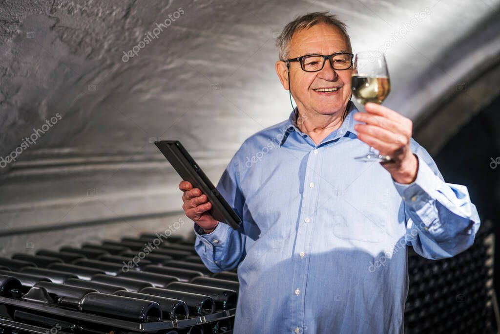 Retrato del hombre mayor que es due o de la bodega. Est examinando la ...