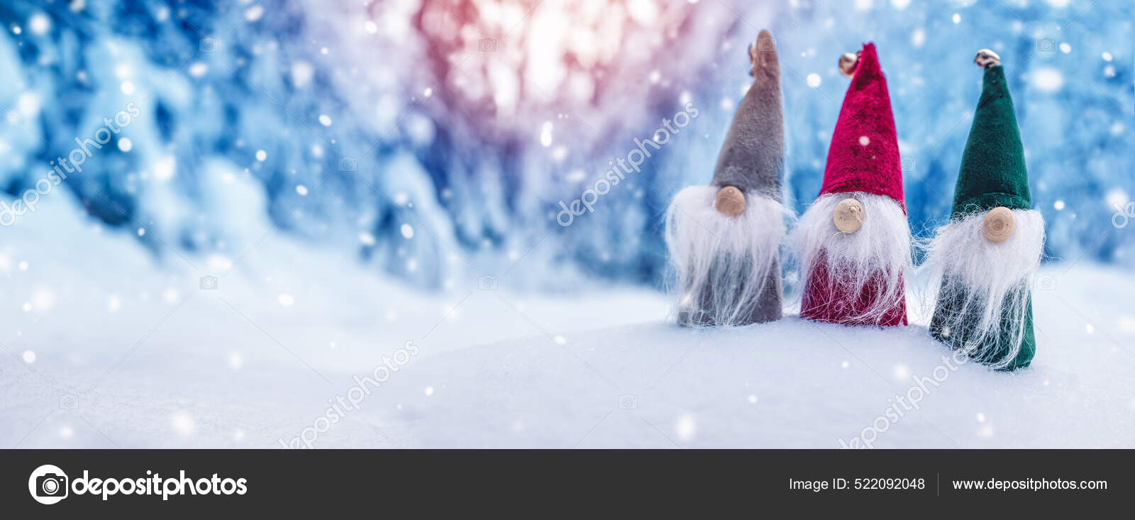 Three cute gnomes in the snowdrift in the winter forest in snowfall ...