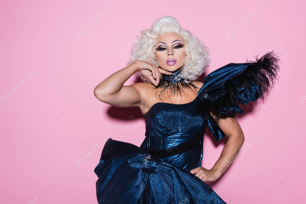 excéntrica drag queen tocando la barbilla mientras posa con la mano en ...
