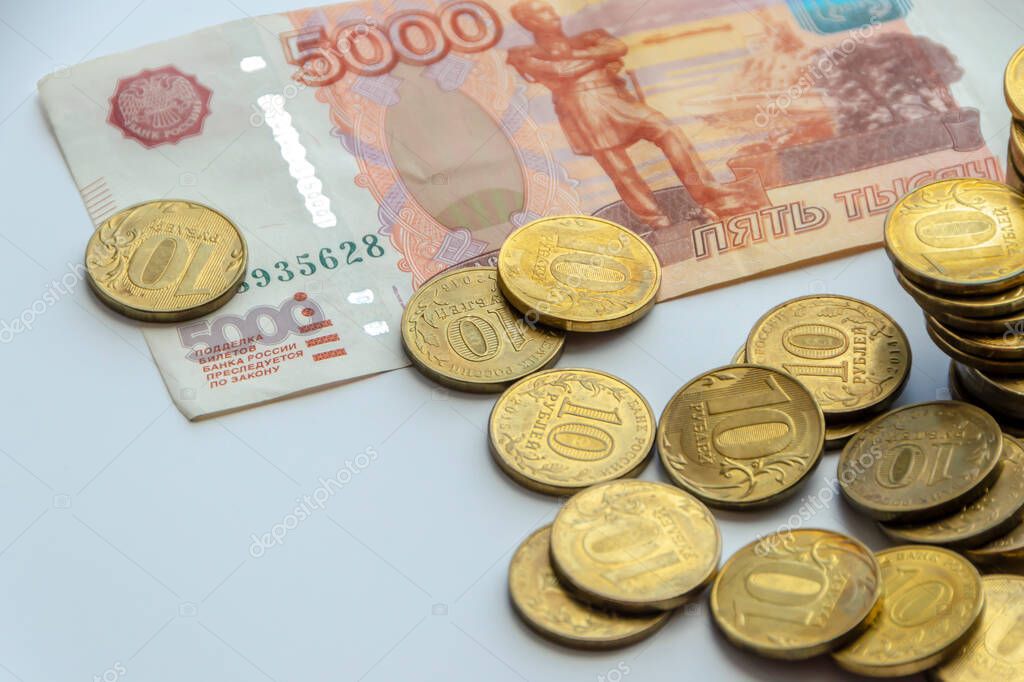 Monedas de oro de hierro en el fondo de un billete con un valor nominal de 5000 rublos. El ...