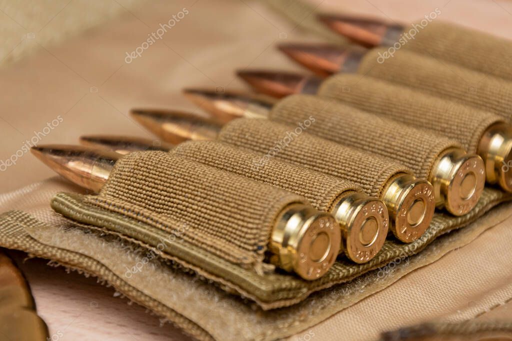 Yellow rifle cartridges with bullets in a 7.62 caliber military ...