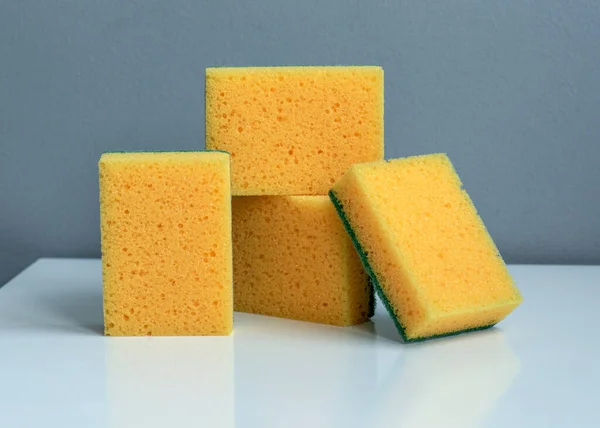 Yellow kitchen sponges on a white table. Sponges for washing dishes and ...