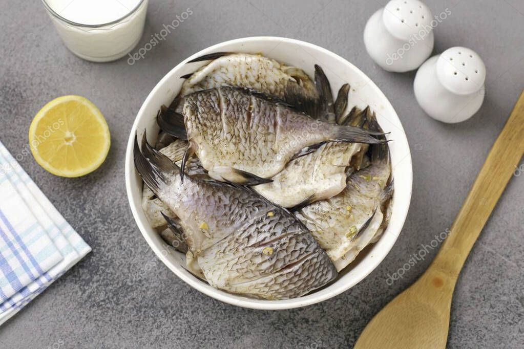 Vierta el jugo de limón en el pescado, frote con sal y especias. Dejar ...