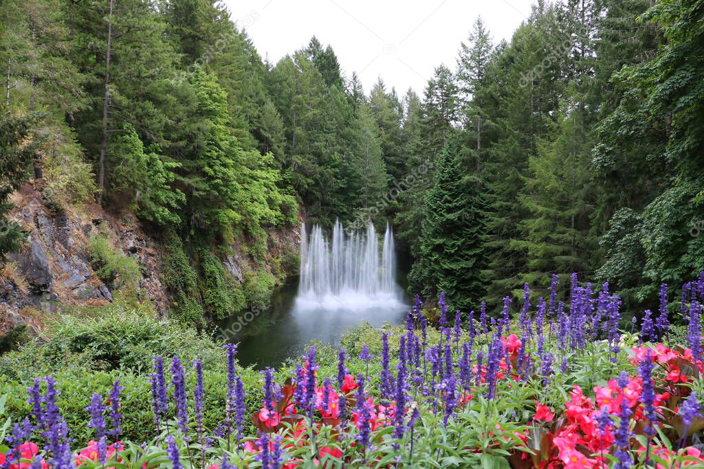 Una fuente forestal entre flores y árboles en el Butchart Garden en ...