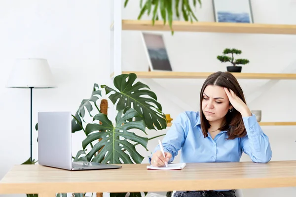 Concentrated businesswoman is doing paperwork while sitting with a ...