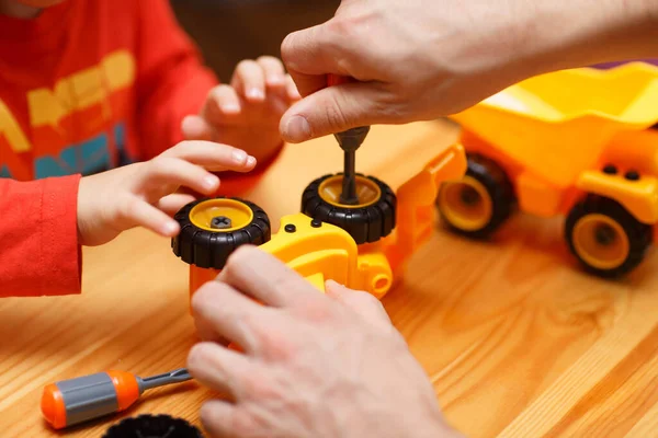 manos del padre y el hijo poner coches de juguete juntos 2023
