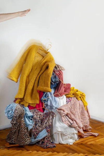 Hand throws clothes into a pile with used clothes. The concept of ...