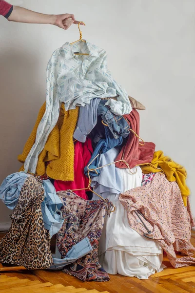 Hand throws clothes into a pile with used clothes. The concept of ...