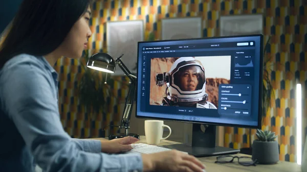 Female asian freelancer editing picture with astronaut on computer in ...
