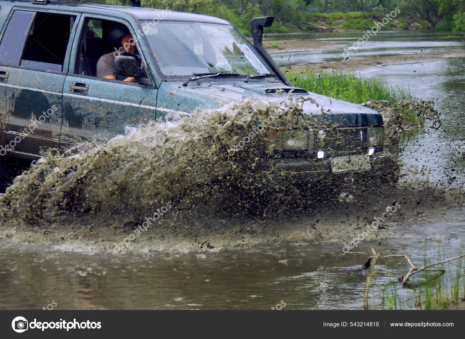 4x4 off-road car crosses a water barrier with splashes at high speed ...