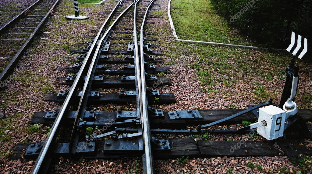 Close-up view of manual railroad switch. Black railroad direction ...