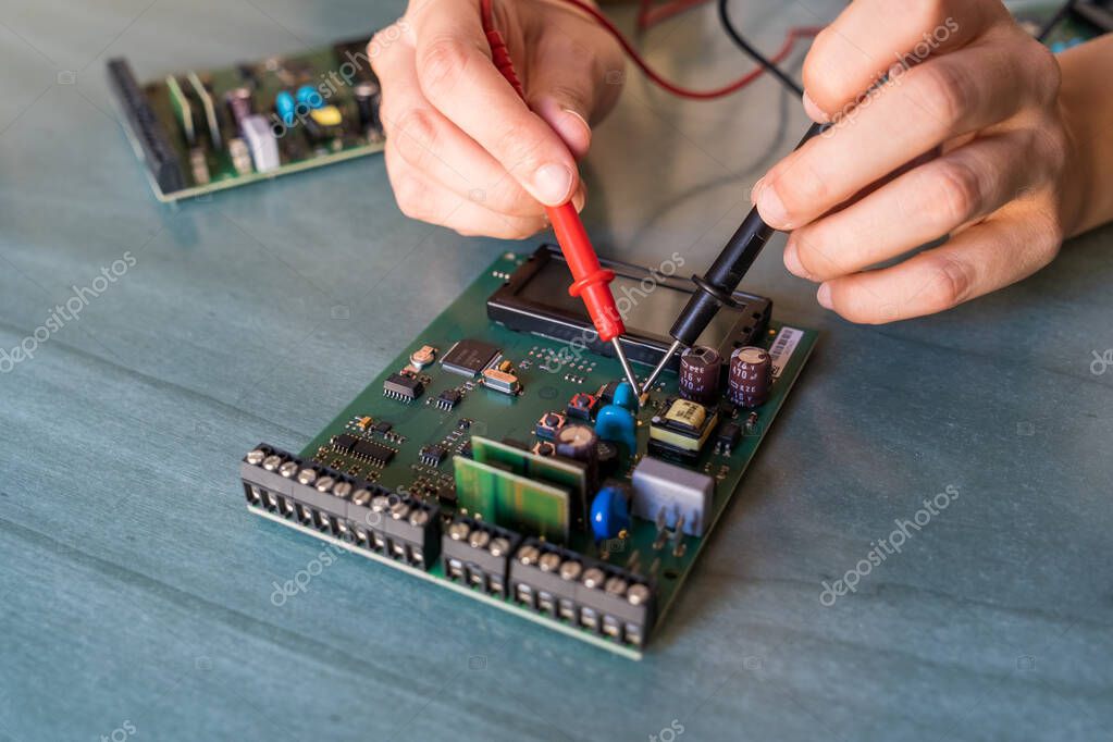 Manos de mujer midiendo una placa base de intercomunicaci n corriente el ctrica 2024