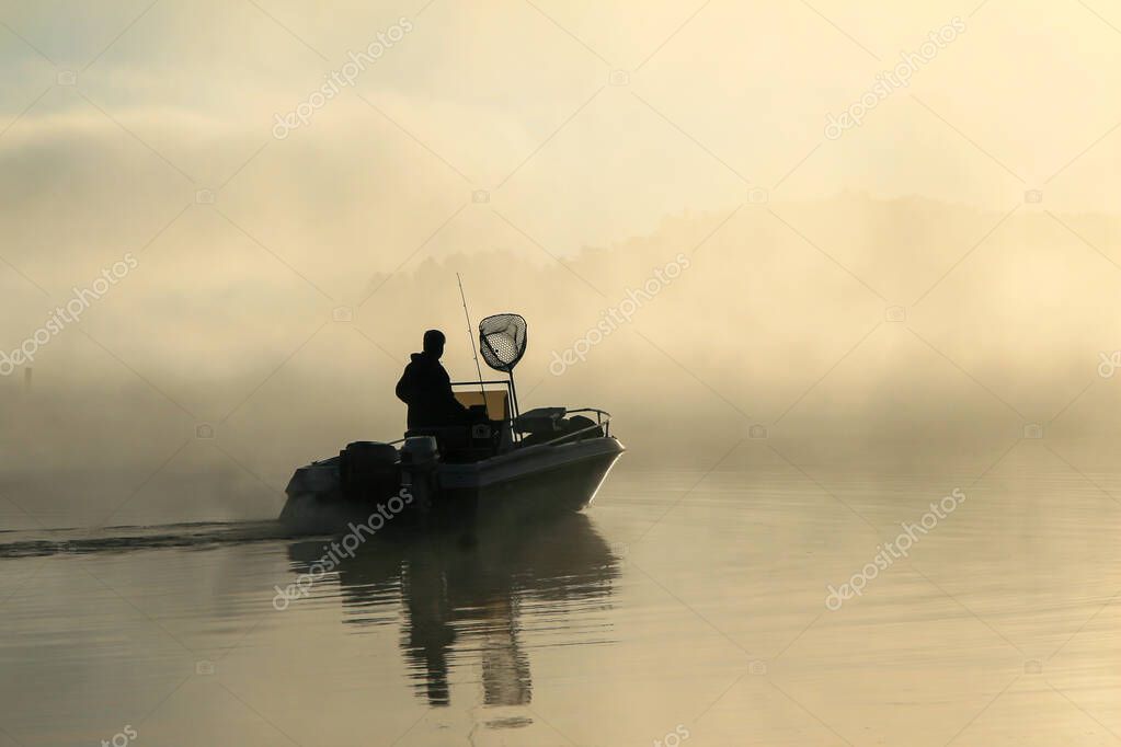 Silueta de un pescador en su barco, temprano en la mañana con mucha ...