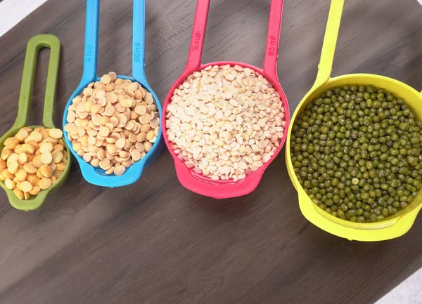 Uncooked pulses, grains and seeds in colorful bowls on wooden ...