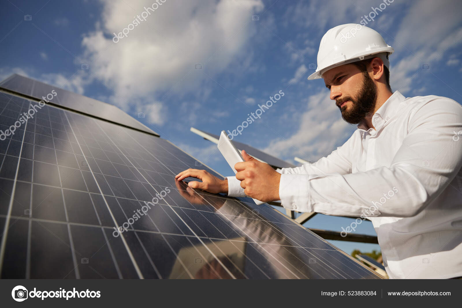 Concentrated male inspector checking solar panels at construction site ...