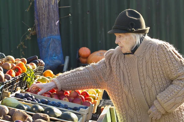Grandma at the farmer's market. Grandmother held out her hand to take ...