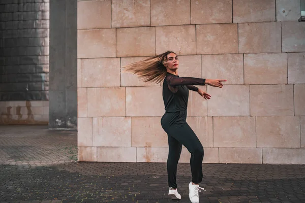 Beautiful young dancer looking away while dancing on the urban city ...