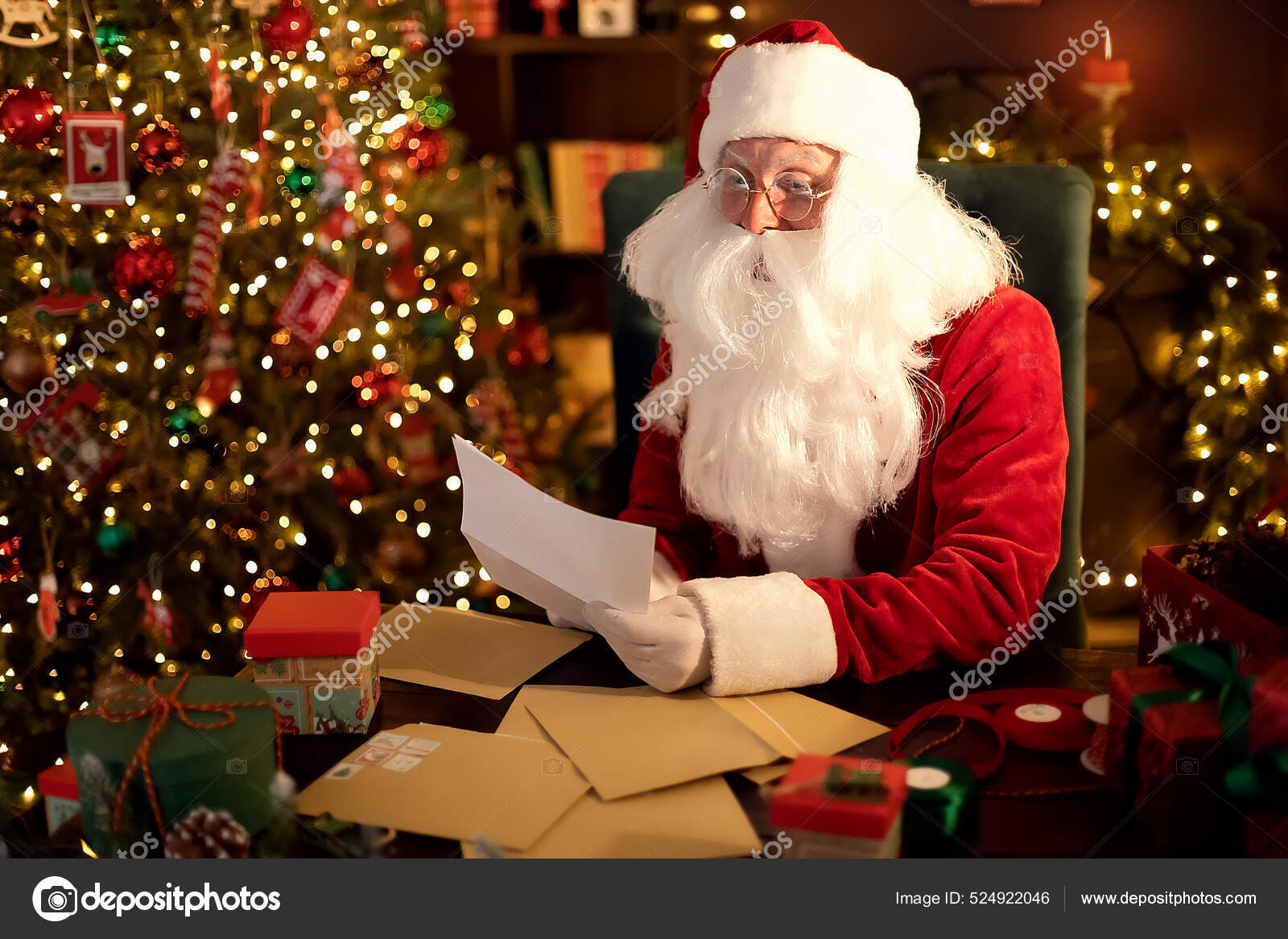 Santa Clause is prepares gifts for children for Xmas at his desk at ...