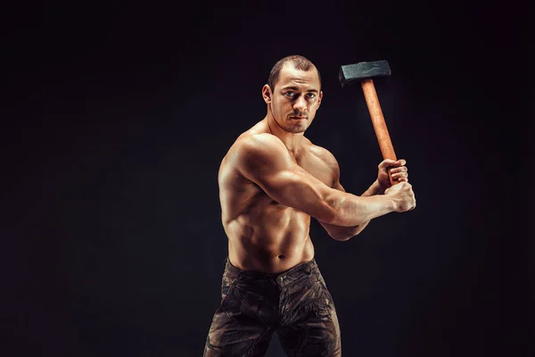 Muscular man with naked torso holding big hummer. Isolated on dark grey ...